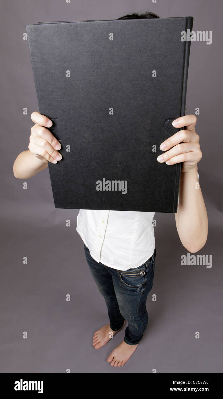 Girl lifts a heavy book Stock Photo - Alamy