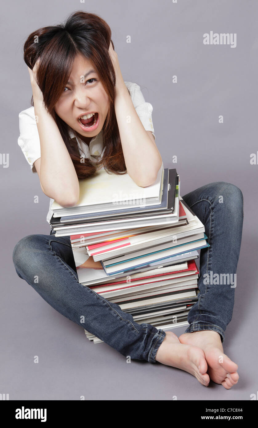 Girl is crazy about studying a pile of books Stock Photo - Alamy