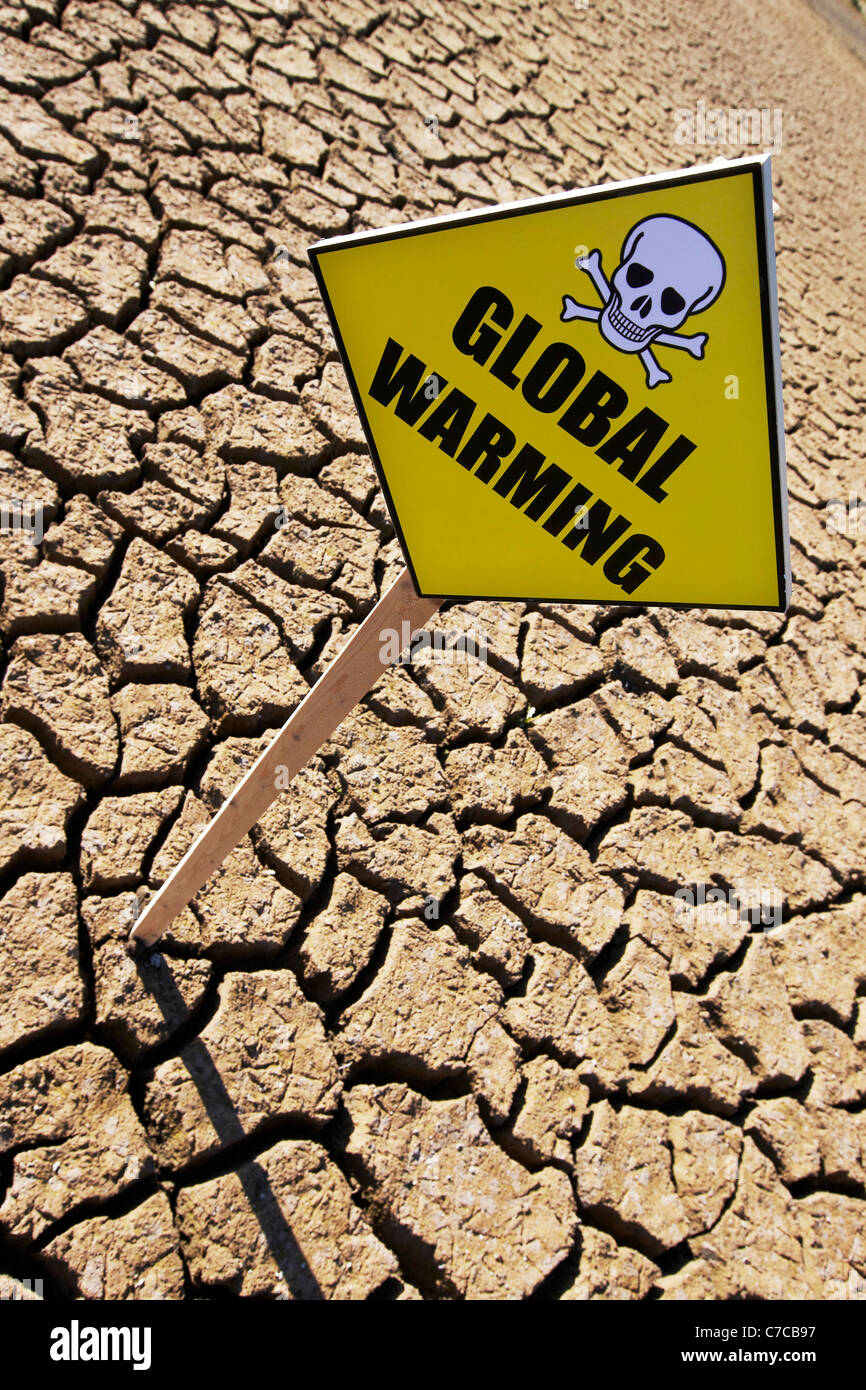 Global warming sign with skull and crossbones on cracked dried river ...