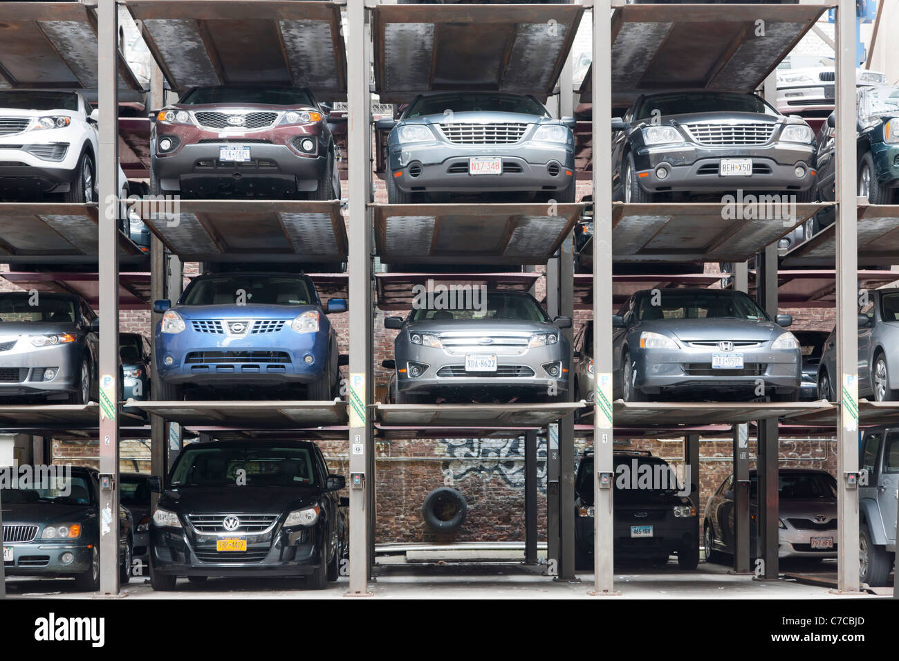 Cars parked in vertical hydraulic parking spaces in a parking lot in ...