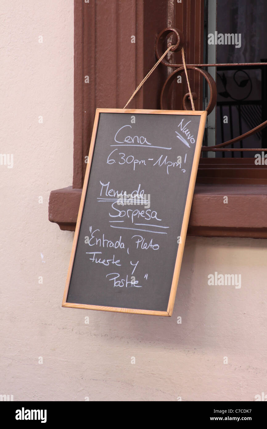 Restaurant menu written in Spanish on a small blackboard with chalk and ...