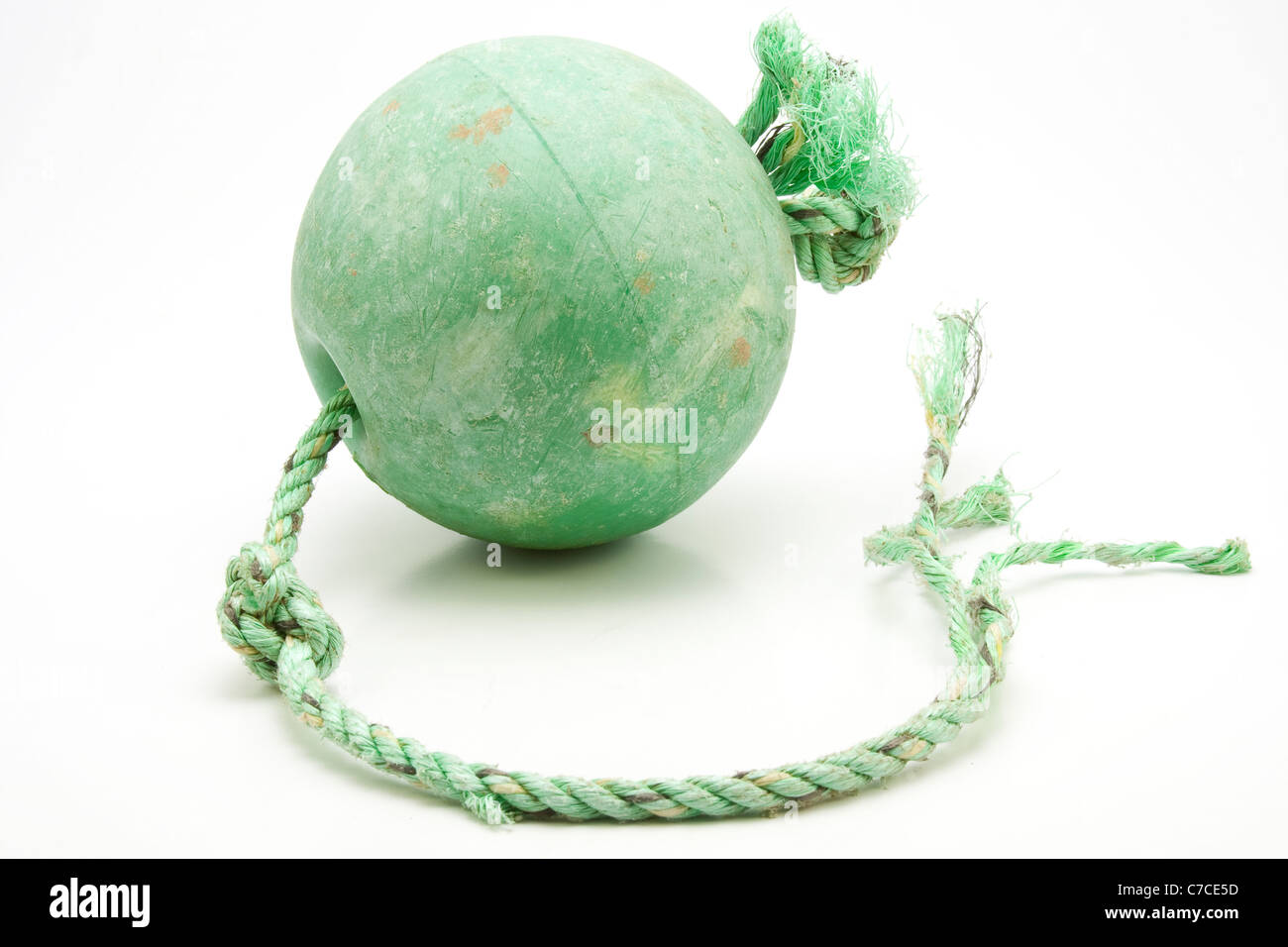 Well used green trawler net float with frayed coloured knotted rope ...