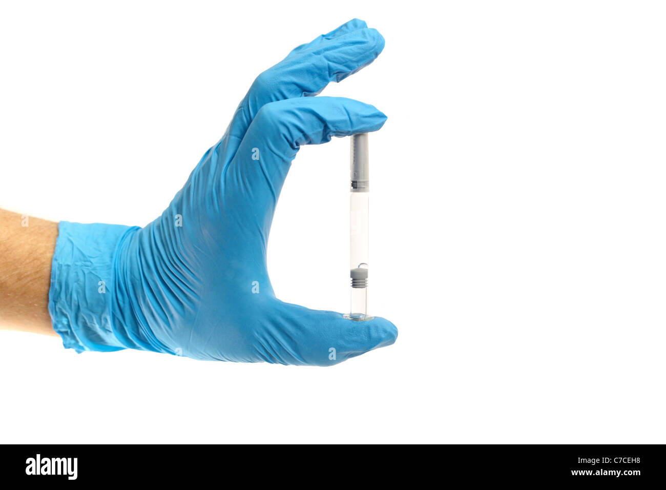 A gloved hand holding a syringe between two fingers Stock Photo - Alamy