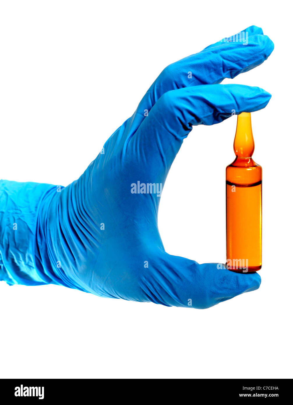 A gloved hand holding a vial between two fingers over a white ...