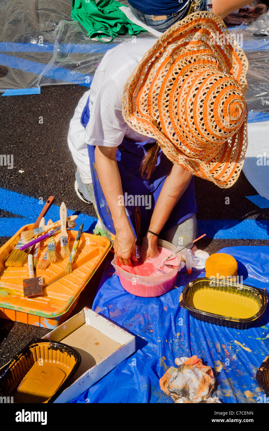 Volunteers paint a city building during a community beautification ...
