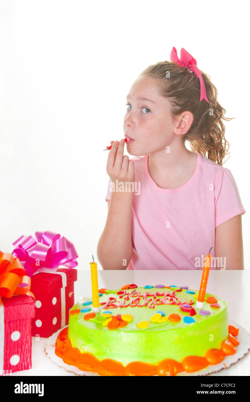 Girl licking icing off birthday candle Stock Photo - Alamy