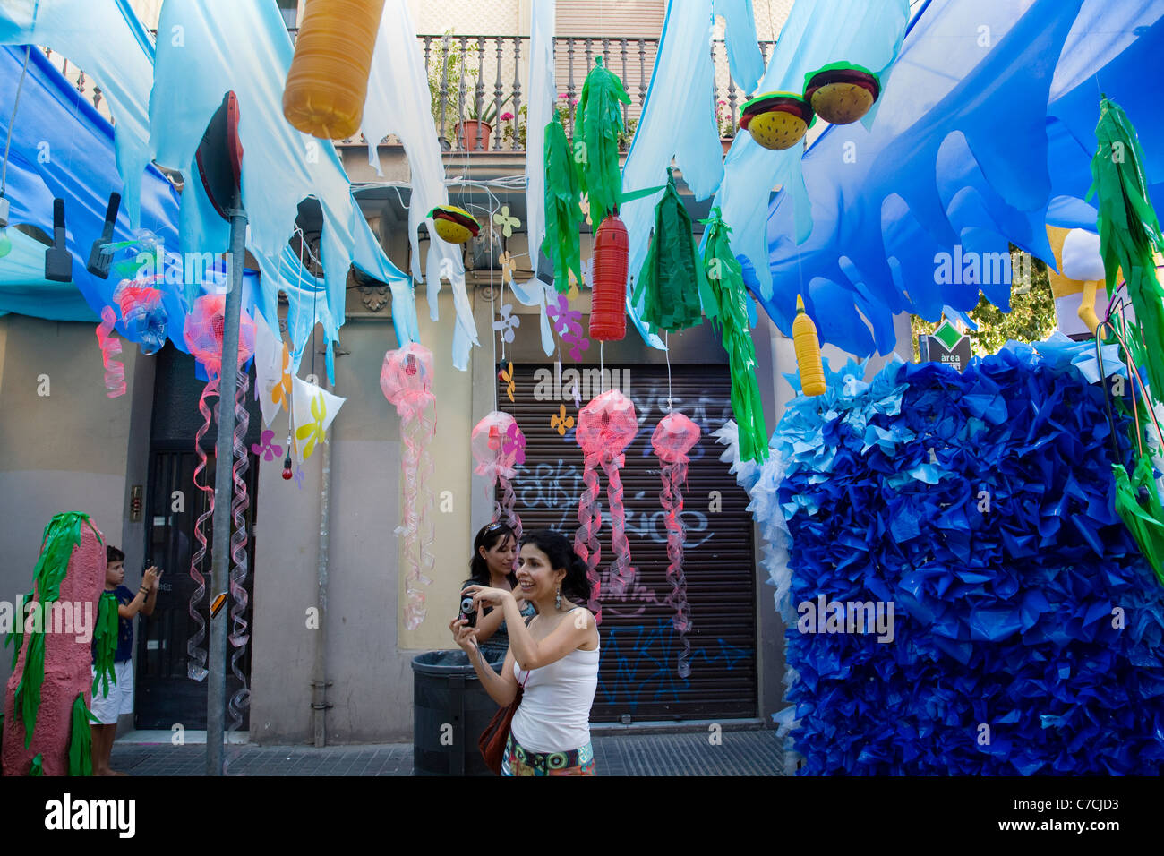 woman taking photograph of decorated street during the "Fiestas de ...