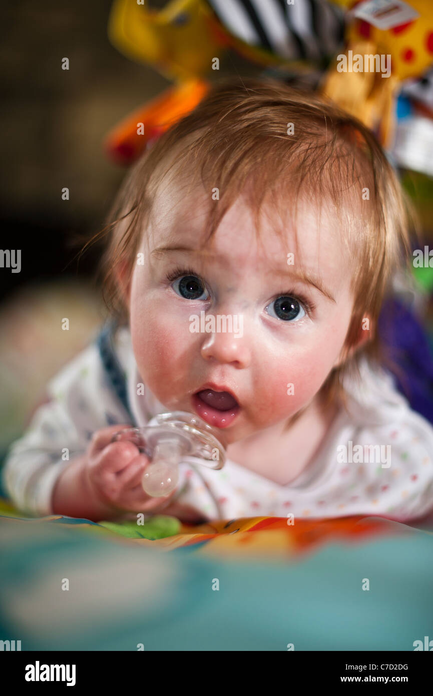 happy smiley cute baby playing with dummy on her play mat Stock Photo ...