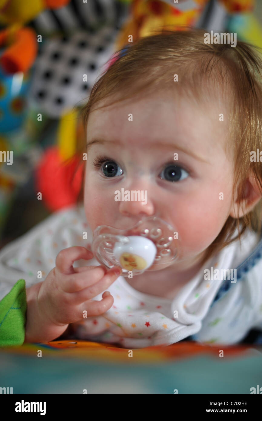 happy smiley cute baby playing with dummy on her play mat Stock Photo ...