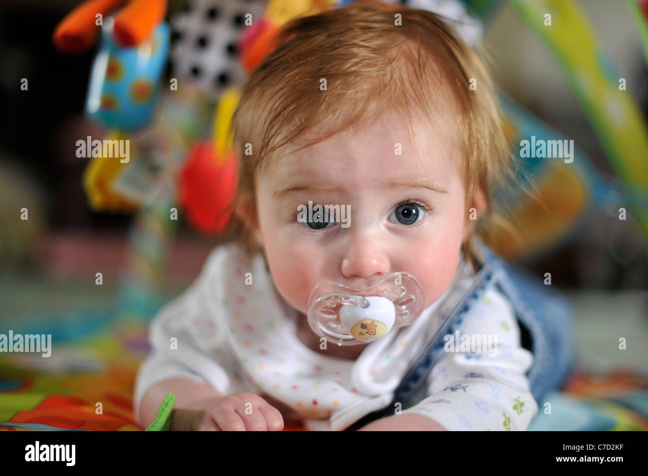 happy smiley cute baby playing with dummy on her play mat Stock Photo ...