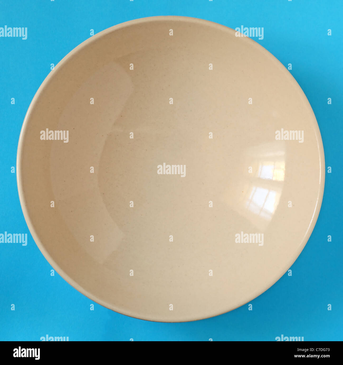 plain porcelain beige dish isolated in blue Stock Photo - Alamy