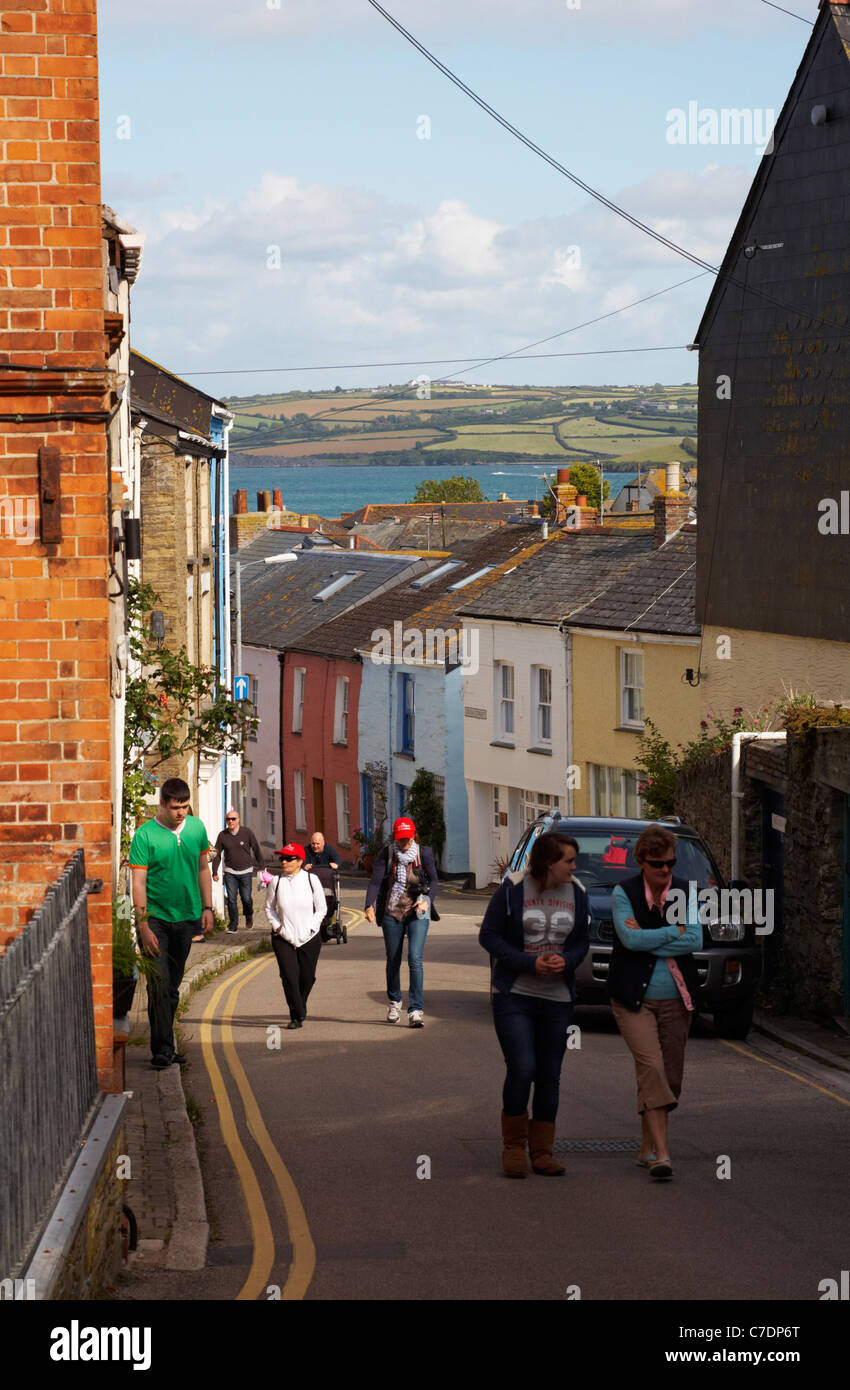 People walking up Cross Street in Padstow with its colourful houses at ...