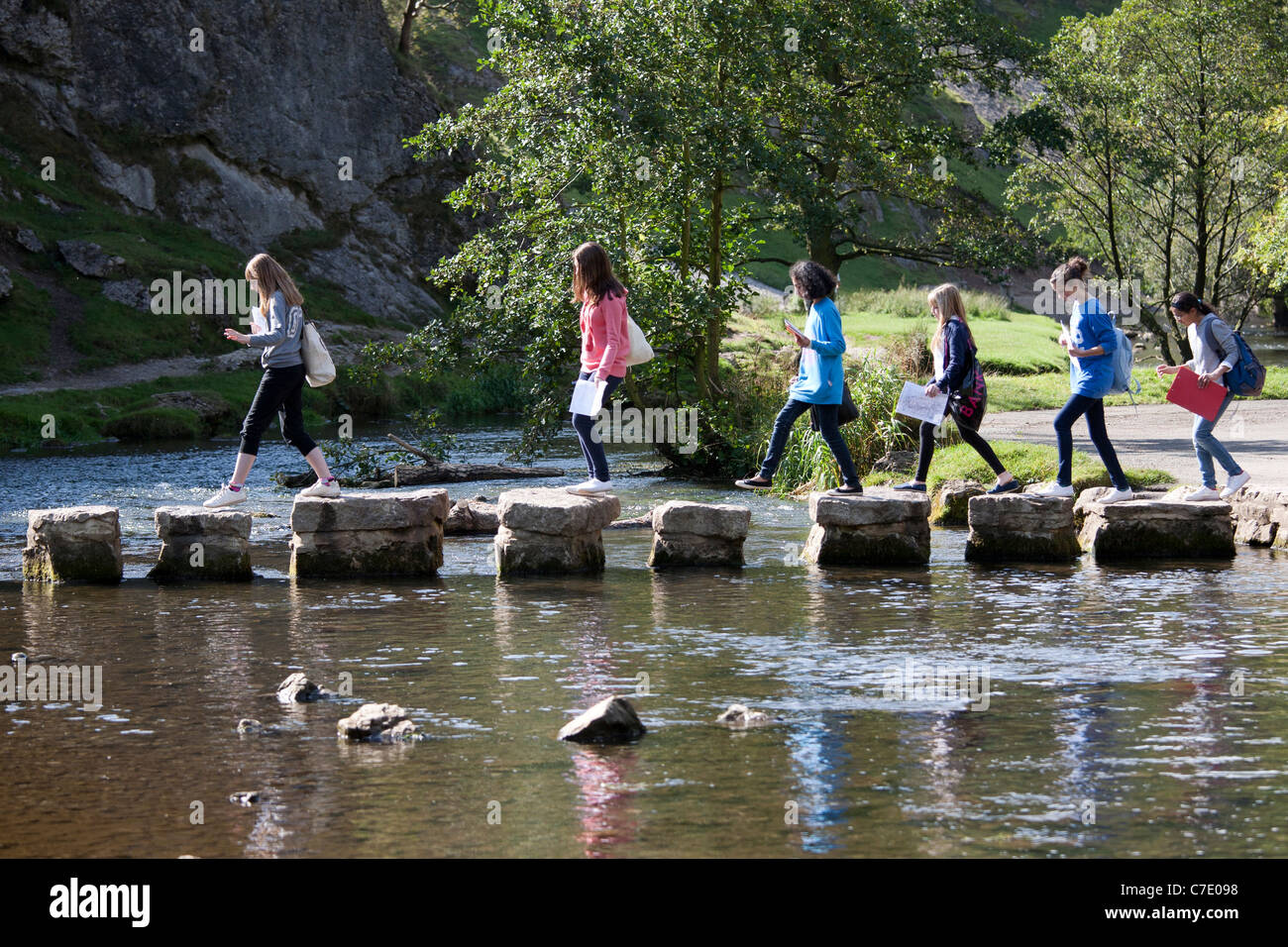 Children walking on the stepping stones in Dovedale, Peak District ...