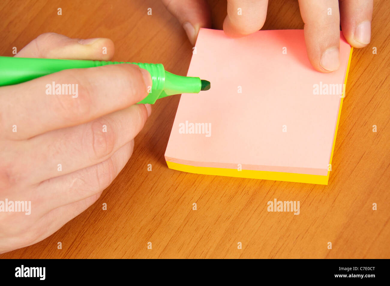 Closeup to male hand writing on post it Stock Photo - Alamy