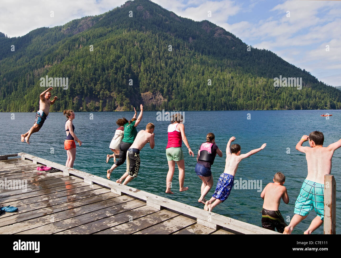 Family leaps into lake from dock, summertime lake fun Stock Photo - Alamy