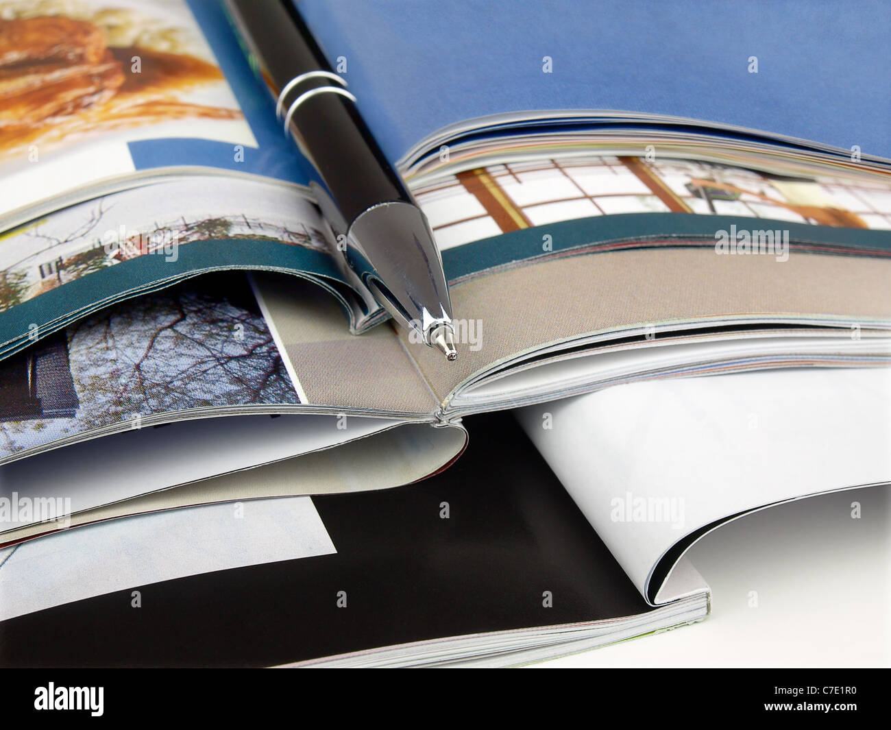 Many colour magazines with pen on top Stock Photo - Alamy