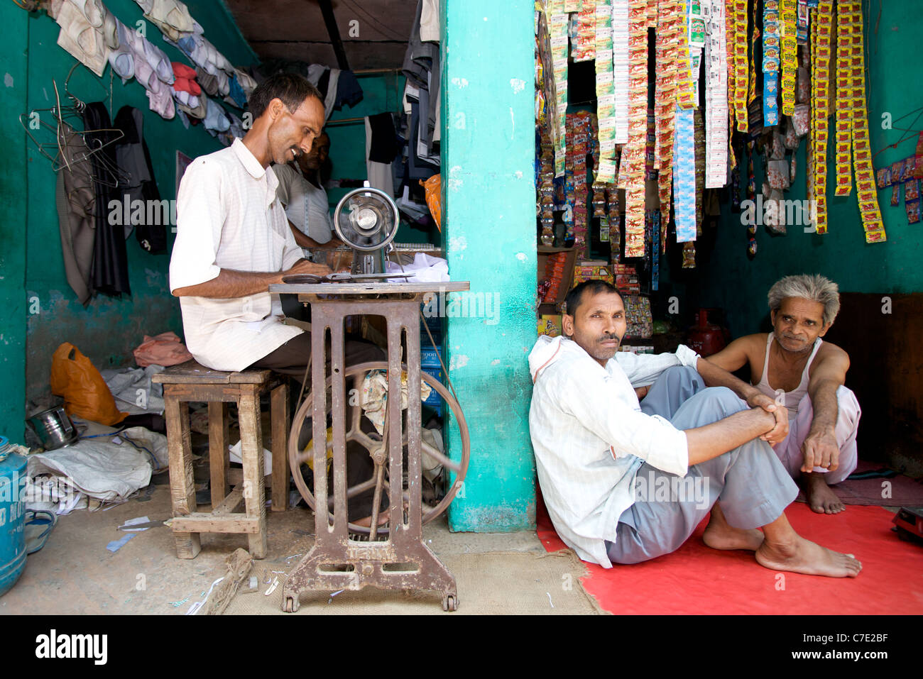 Asian man working on a sewing machine in a shop on a street in Old ...