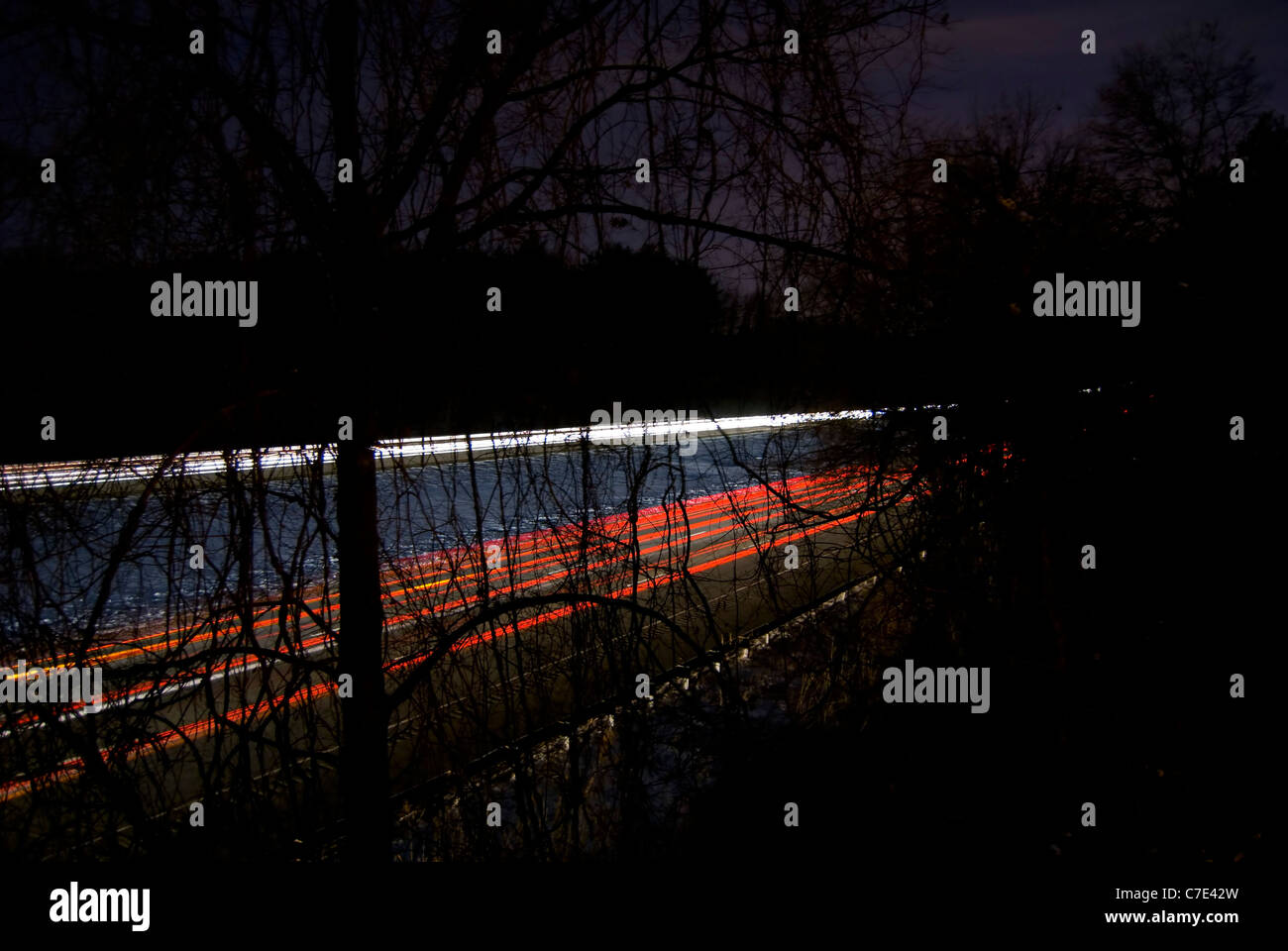A nighttime highway shot using slow shutterspeed - glowing light trails ...