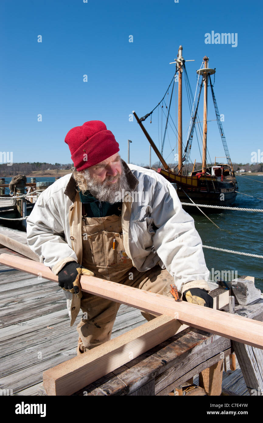 Man carving a spar for a ship on a dock Stock Photo - Alamy