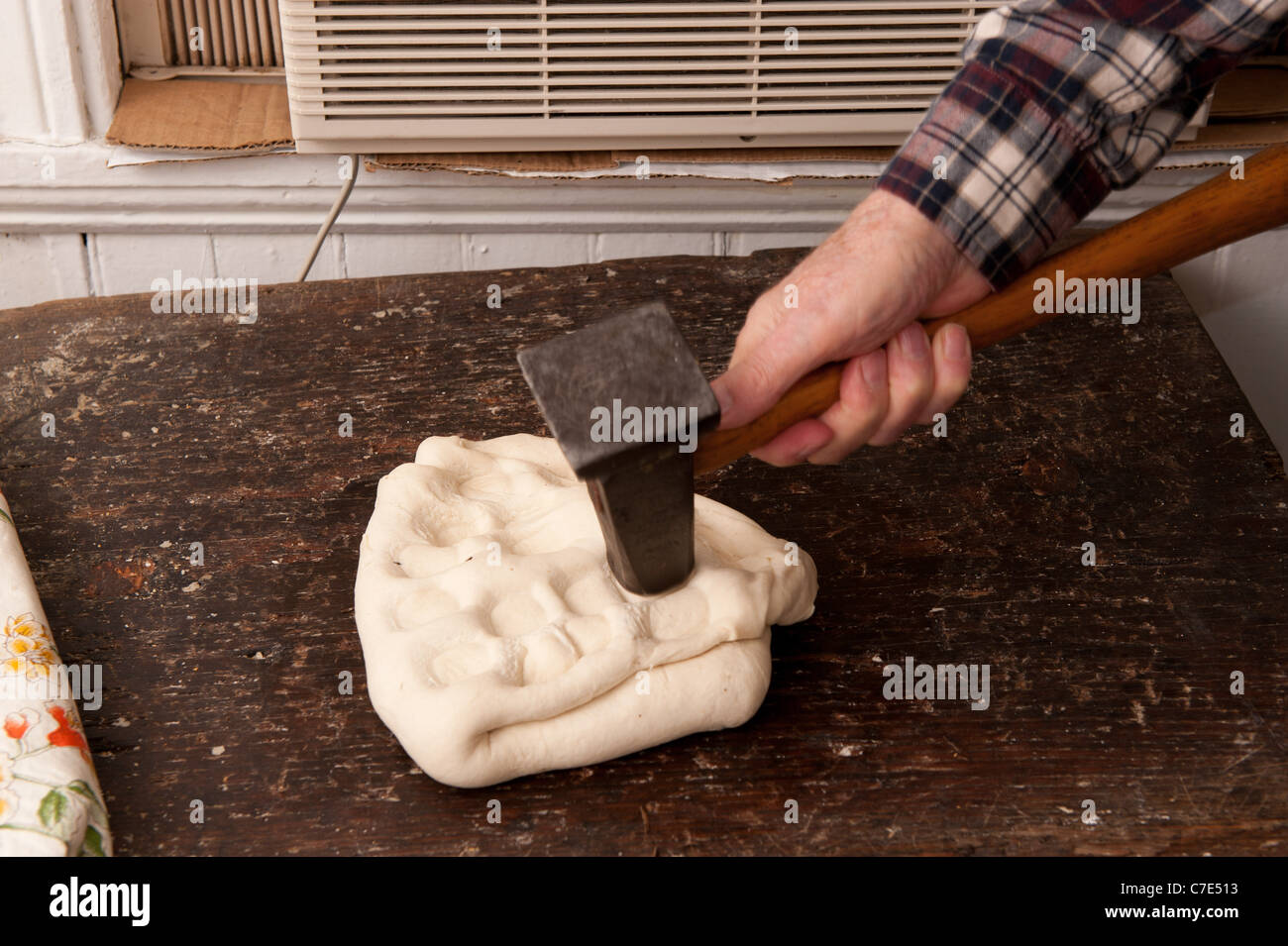 man demonstrating beating in the process of making beaten biscuits ...
