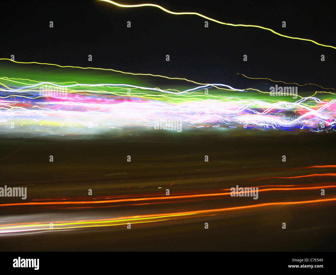 Abstract light trails captured from cars signs and other landmarks at ...