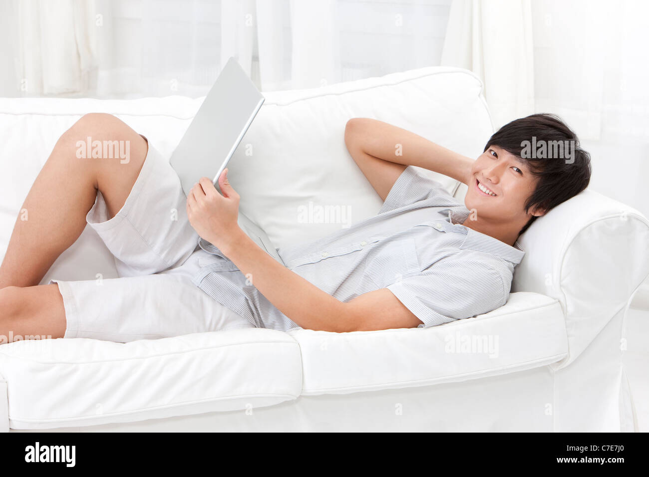 Young Man Using Tablet at Home Stock Photo - Alamy