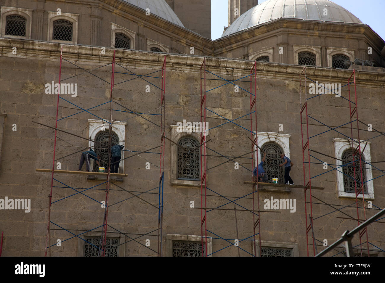 Men working on windows from precarious looking scaffolding, Cairo ...