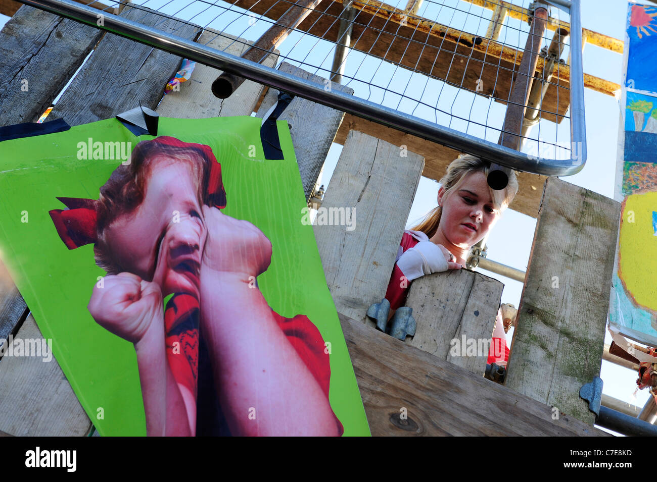 A young girl peers through barriers erected at Dale Farm Gypsy Site to ...