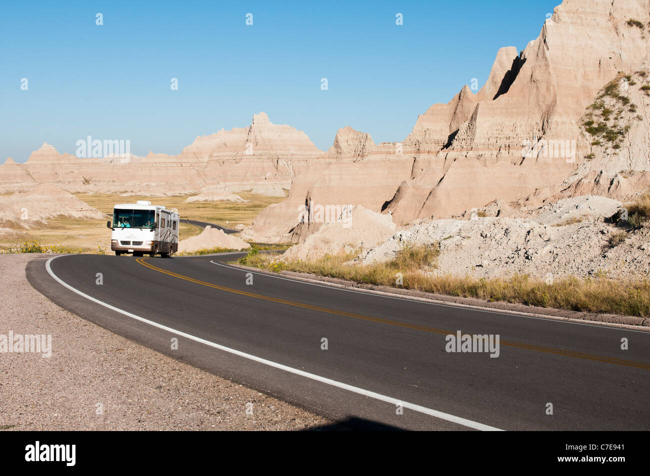 Tourists in a recreational vehicle drive through Badlands National Park ...