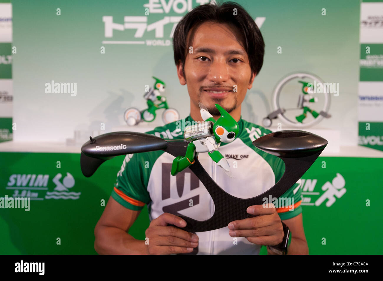 Tomotaka Takahashi poses for a photograph as he holds up the new swim ...