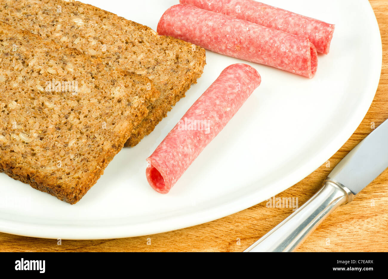 Rolled slices of salami served with pumpernickel bread Stock Photo - Alamy