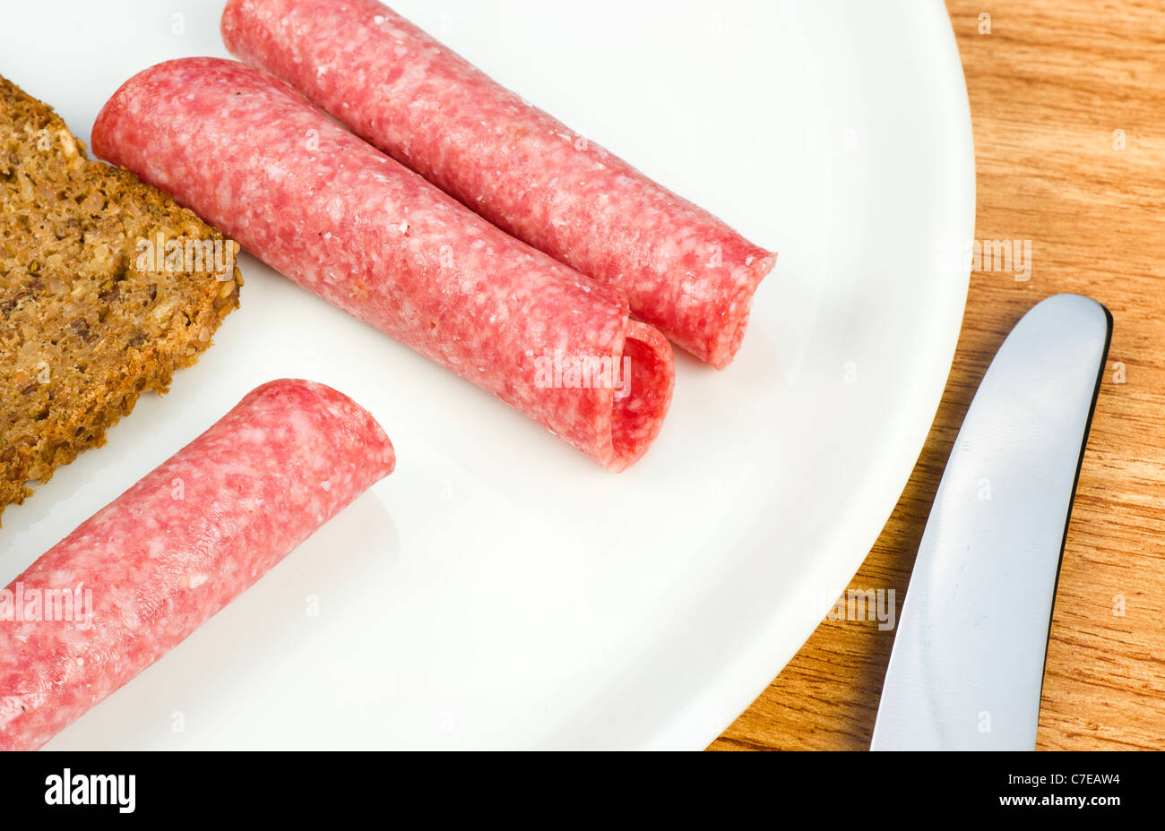Rolled slices of salami served with pumpernickel bread Stock Photo - Alamy
