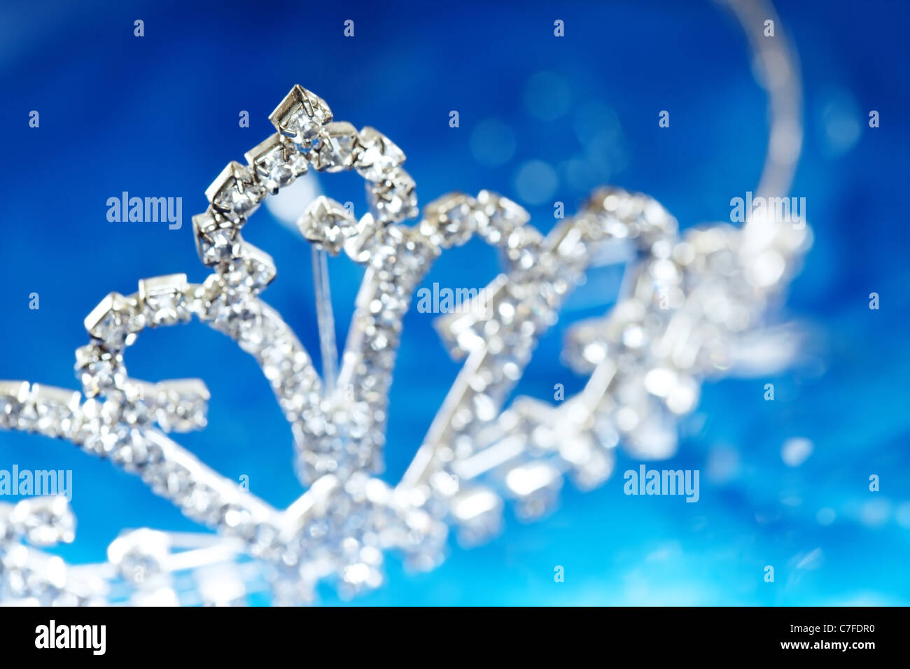 Close-up photo of the silver diadem with diamonds on a blue background ...