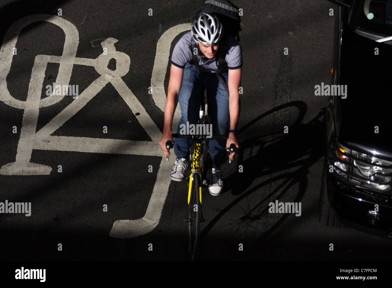 looking down on a cyclist cycling passed a cycle waiting zone at a set ...