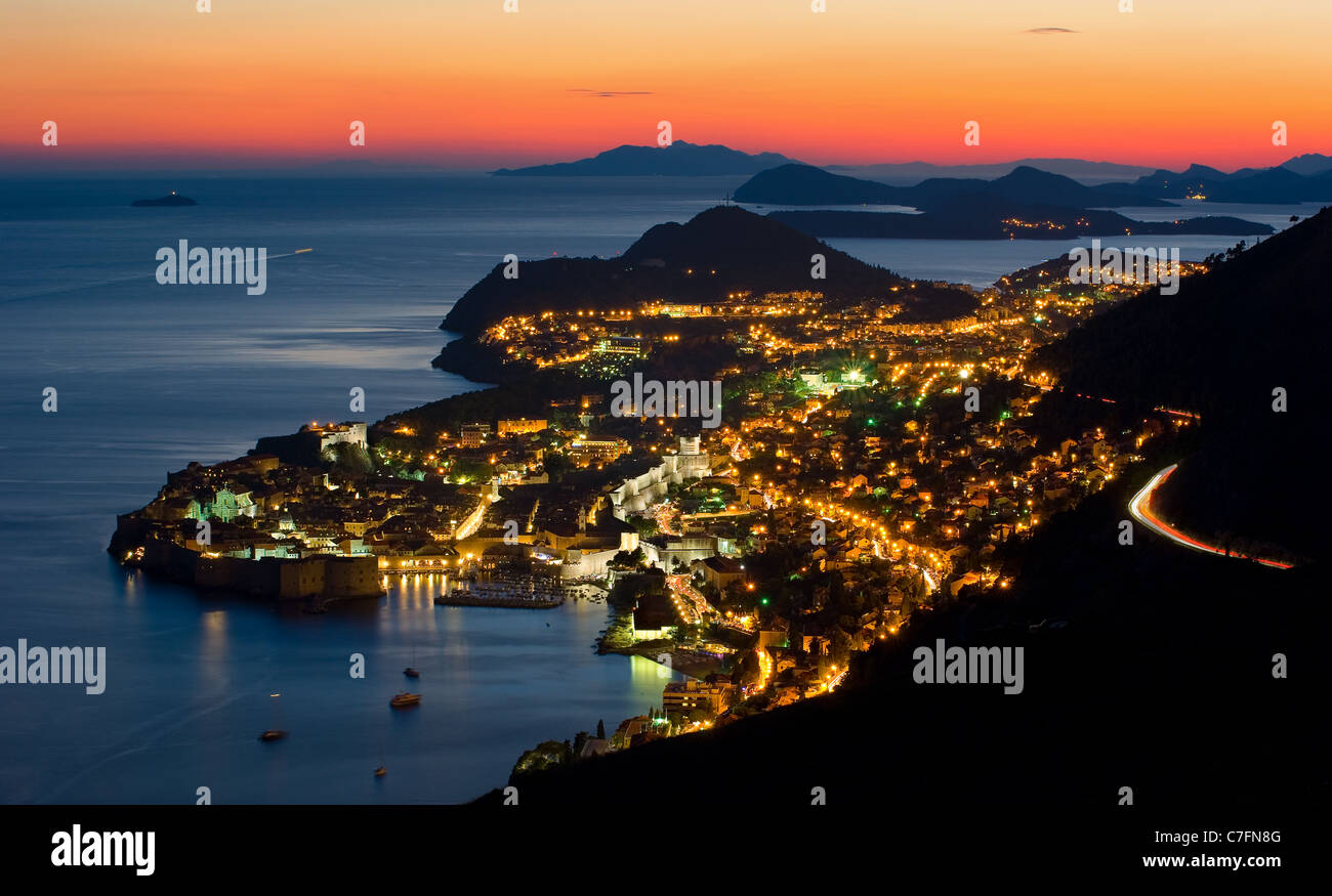 Dubrovnik at dusk, with the city lights and red sky in the background ...
