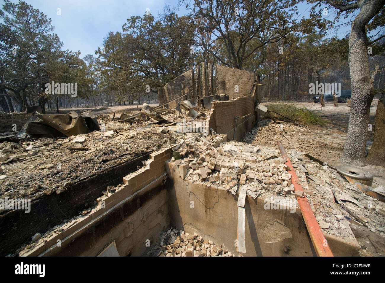 Foundation and partial wall of a burned-out home after wildfire swept ...