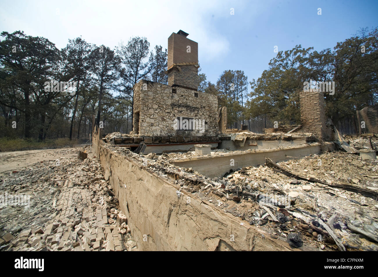 Foundation and partial wall of a burned-out home after wildfire swept ...