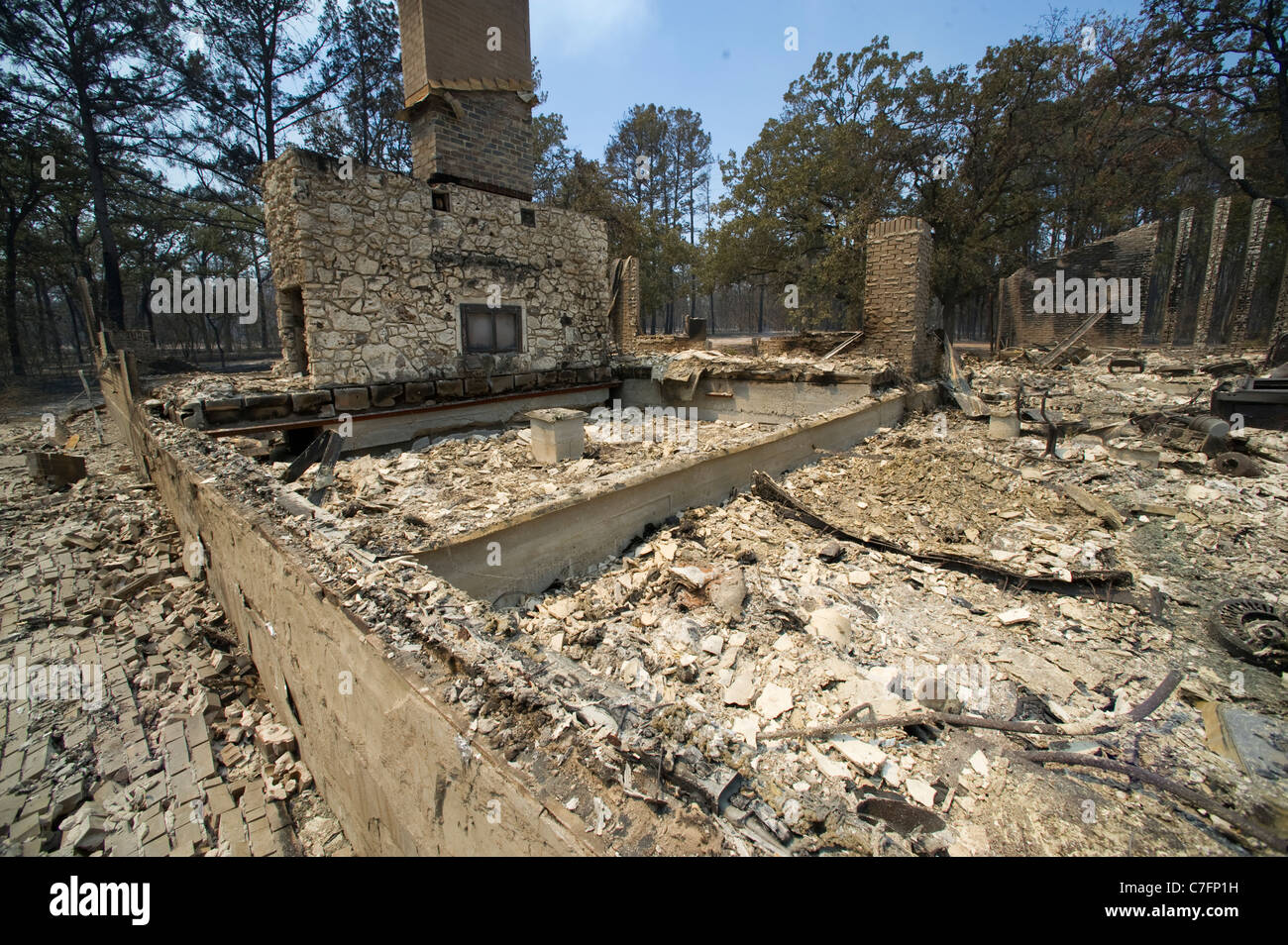 Foundation and partial wall of a burned-out home after wildfire swept ...