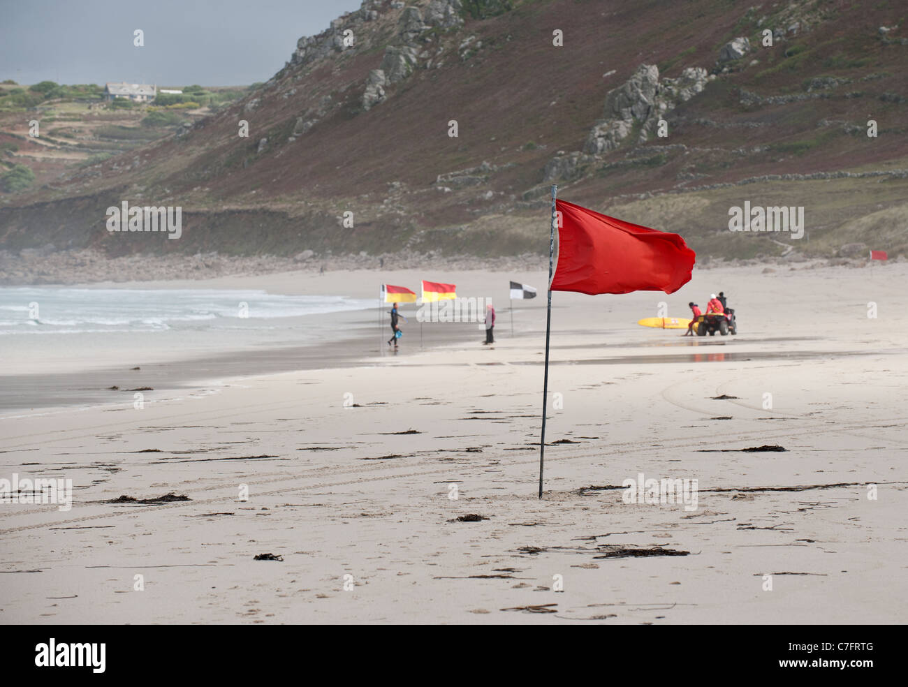 A red warning flag on Sennen Beach in Cornwall Stock Photo - Alamy