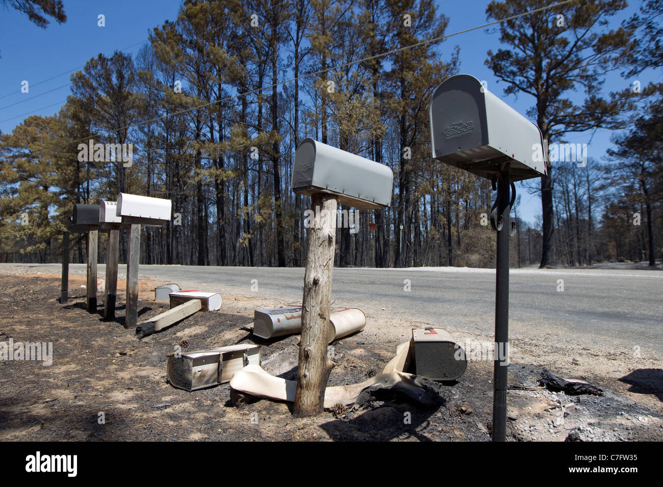 A row of damaged and intact mailboxes shows the aftermath of wildfire ...