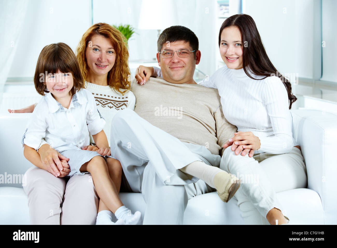 Photo of happy family looking at camera at home Stock Photo - Alamy