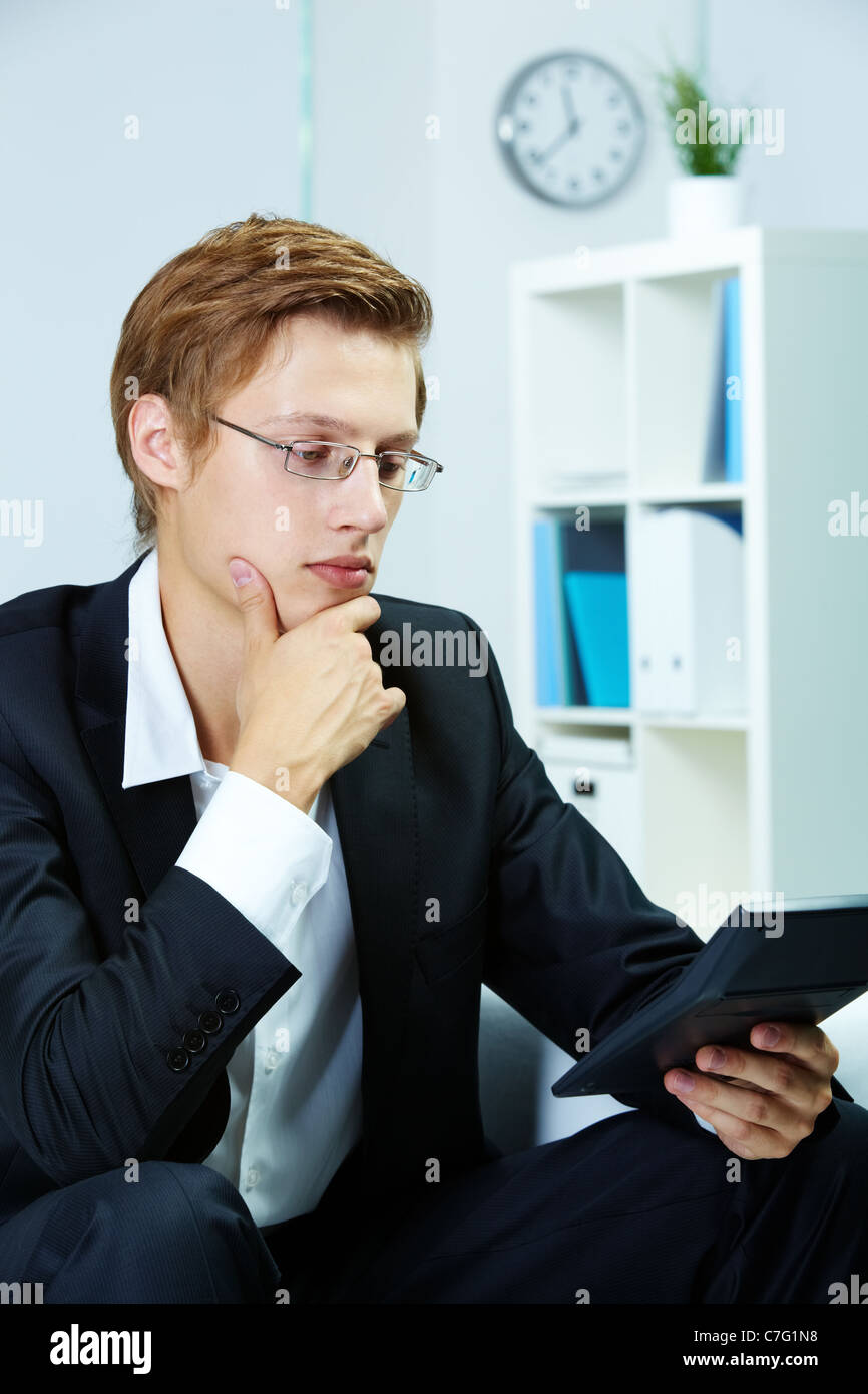 Portrait of a serious accountant looking at calculator tableau Stock ...