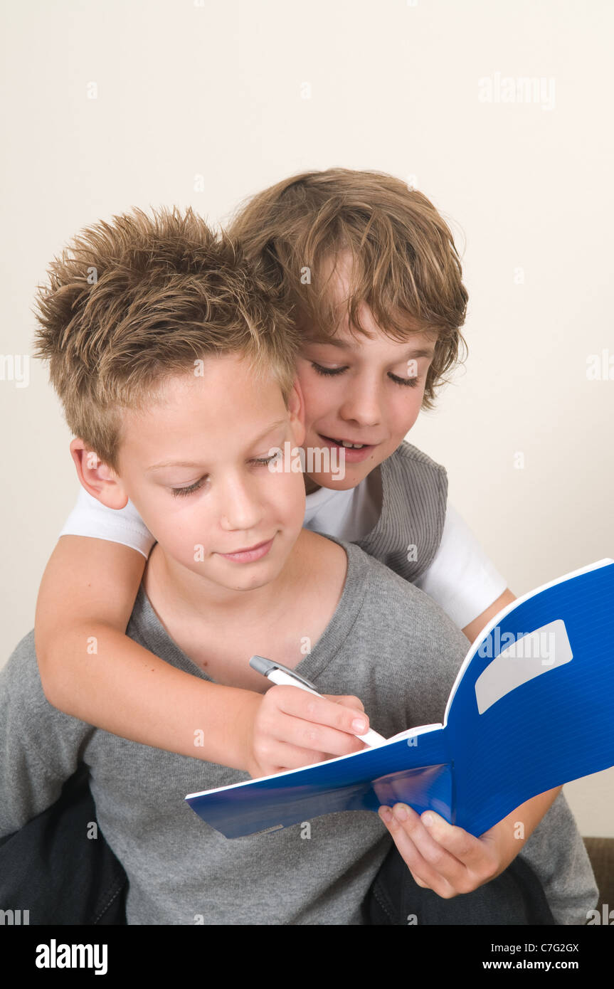 Two friends doing their homework in the livingroom Stock Photo - Alamy