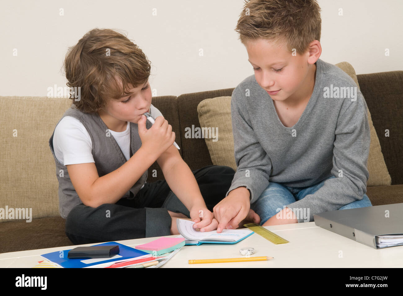 Two friends doing their homework in the livingroom Stock Photo - Alamy