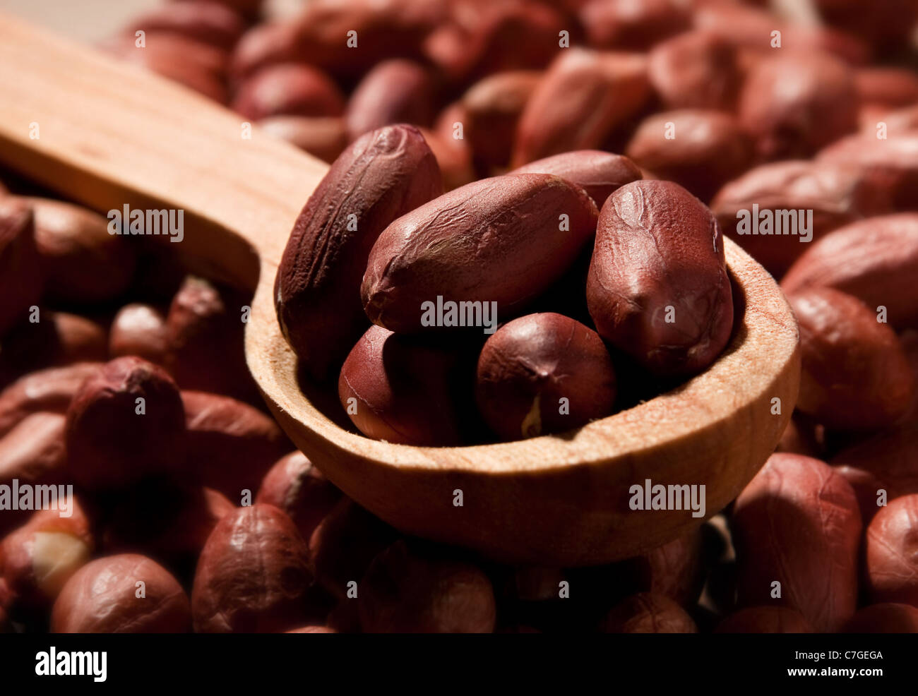 Peanut nut fruit with wood spoon on brown background Stock Photo - Alamy