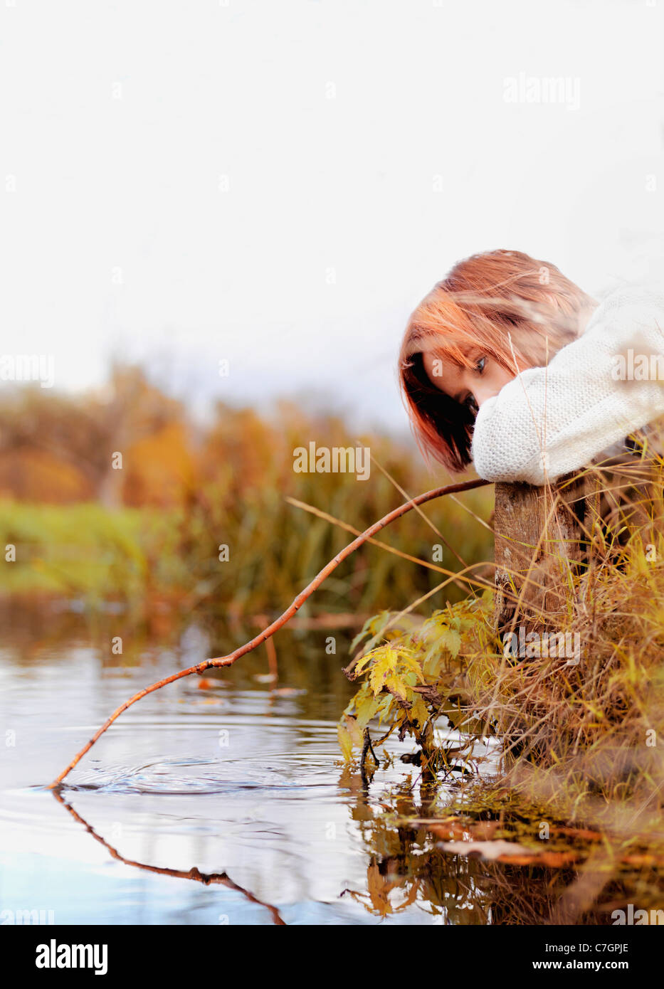 A woman dipping a stick in a stream Stock Photo - Alamy