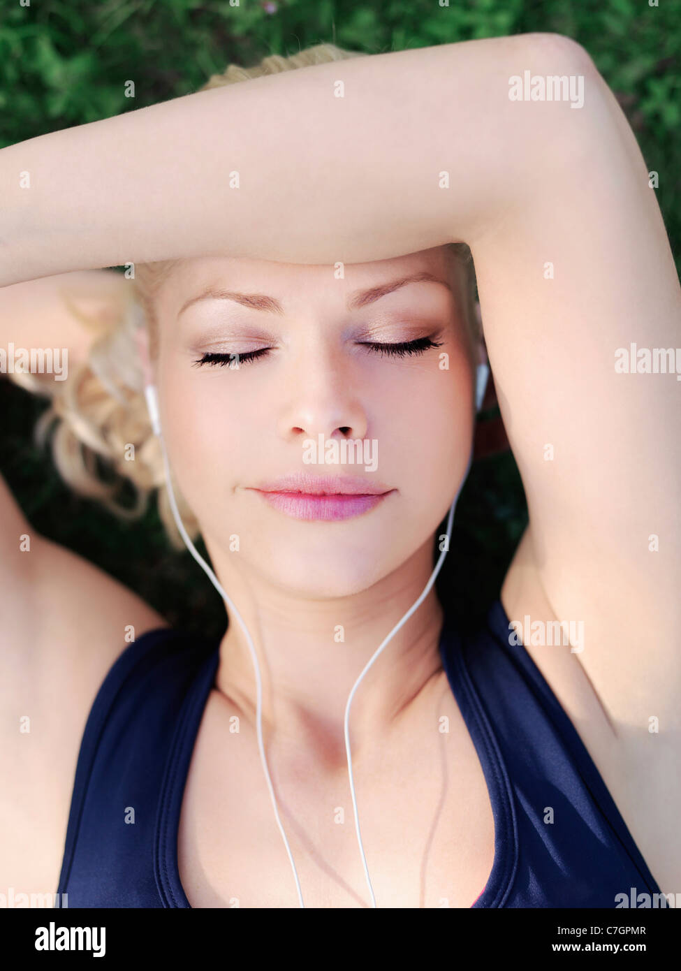 A Woman Wearing Earphones With Her Eyes Closed Close Up Head And