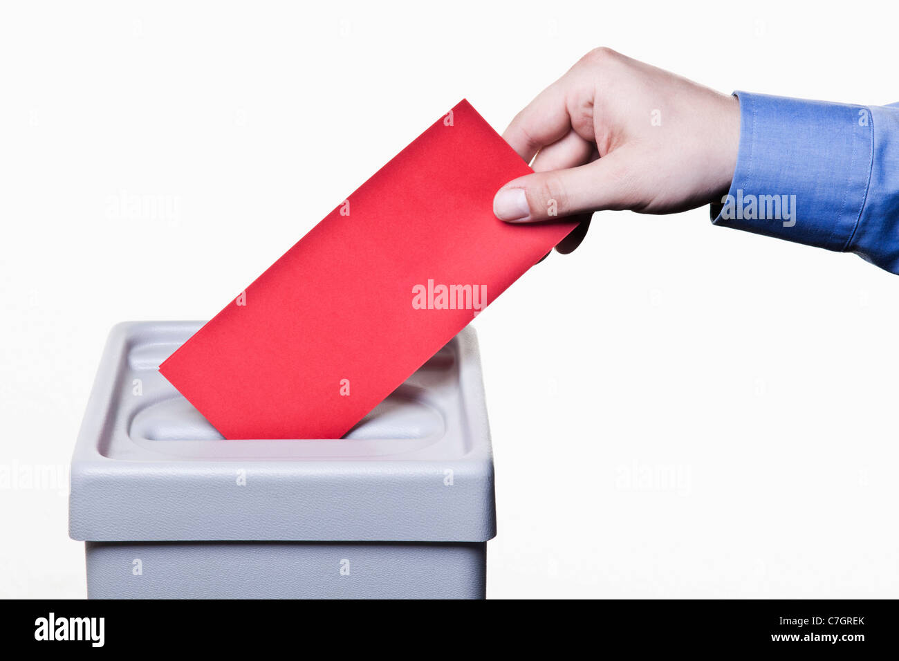 A man putting a blank red ballot into a ballot box, close-up hands ...