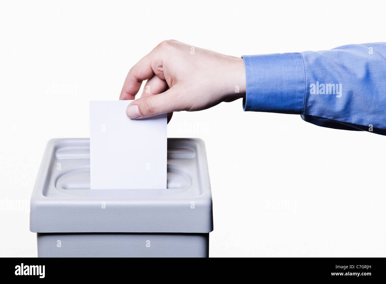 A man putting a blank white ballot into a ballot box, close-up hands ...