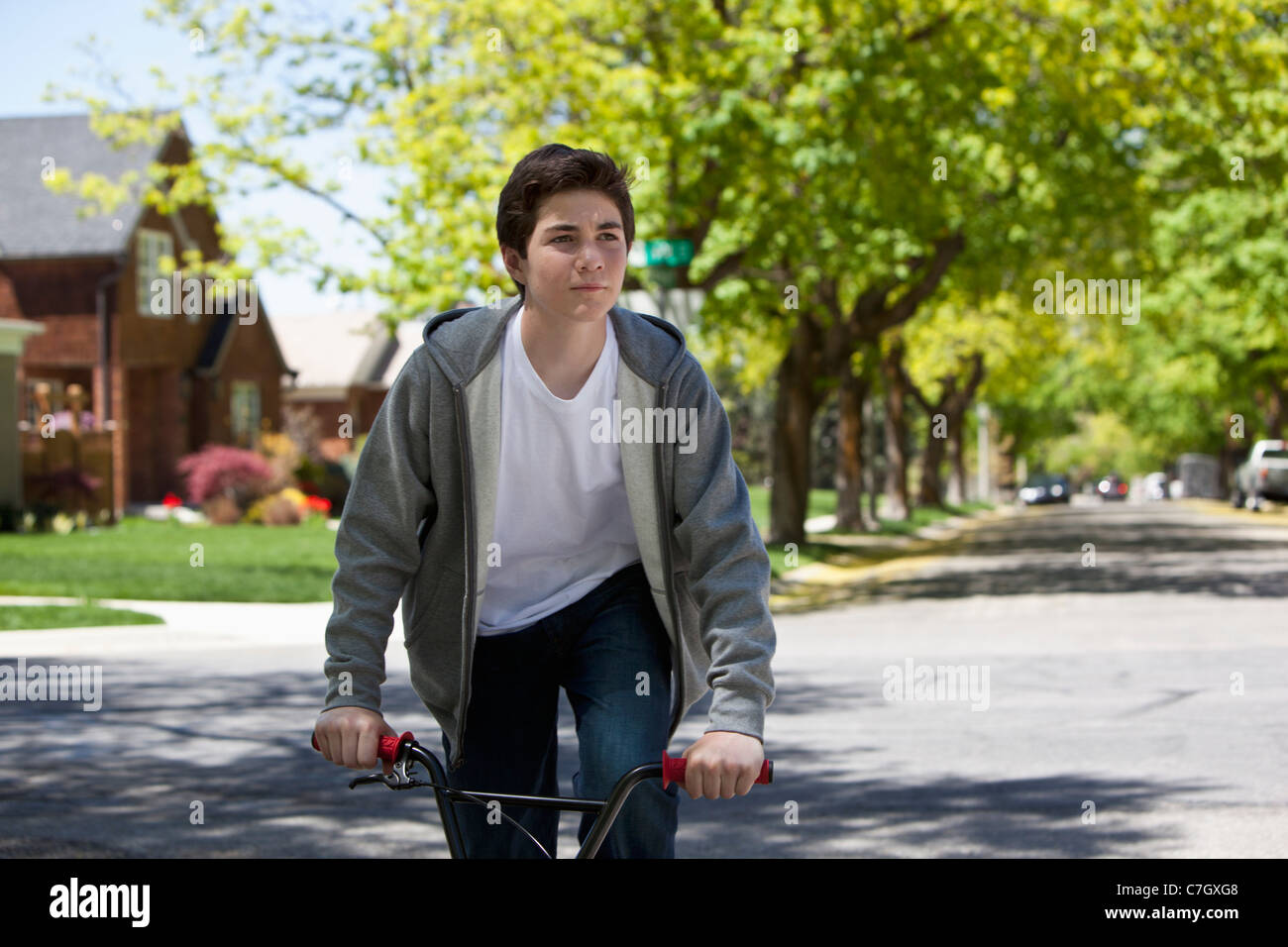 Boy standing while riding bike Stock Photo - Alamy